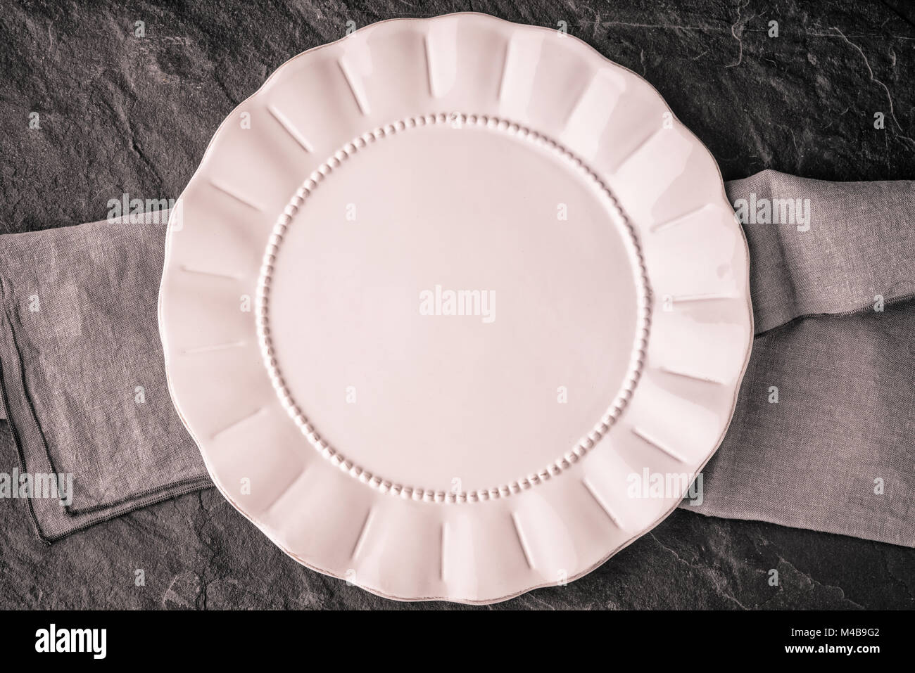 White plate on the dark stone table top view Stock Photo - Alamy