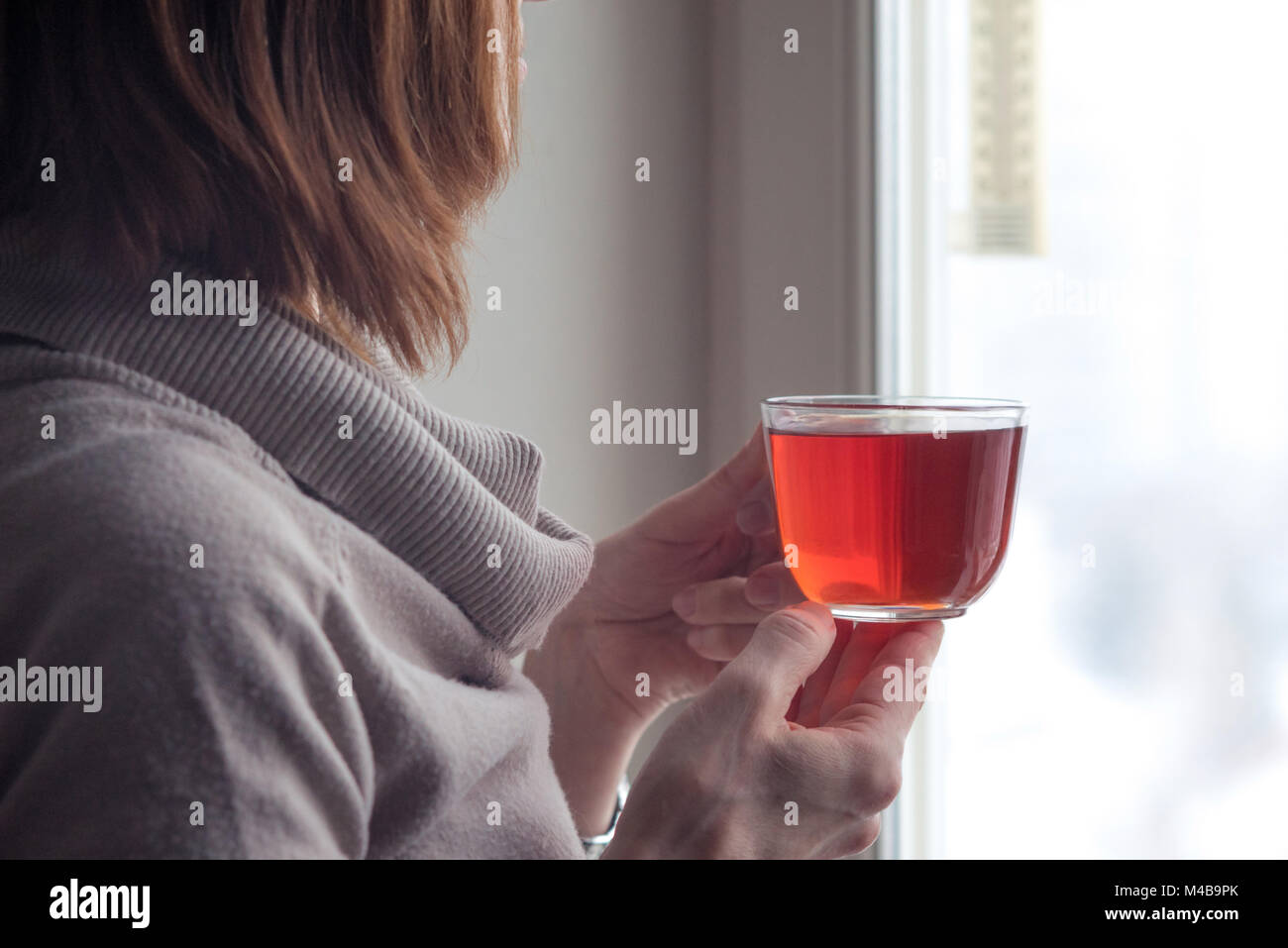 Woman with cup of tea near the window Stock Photo - Alamy