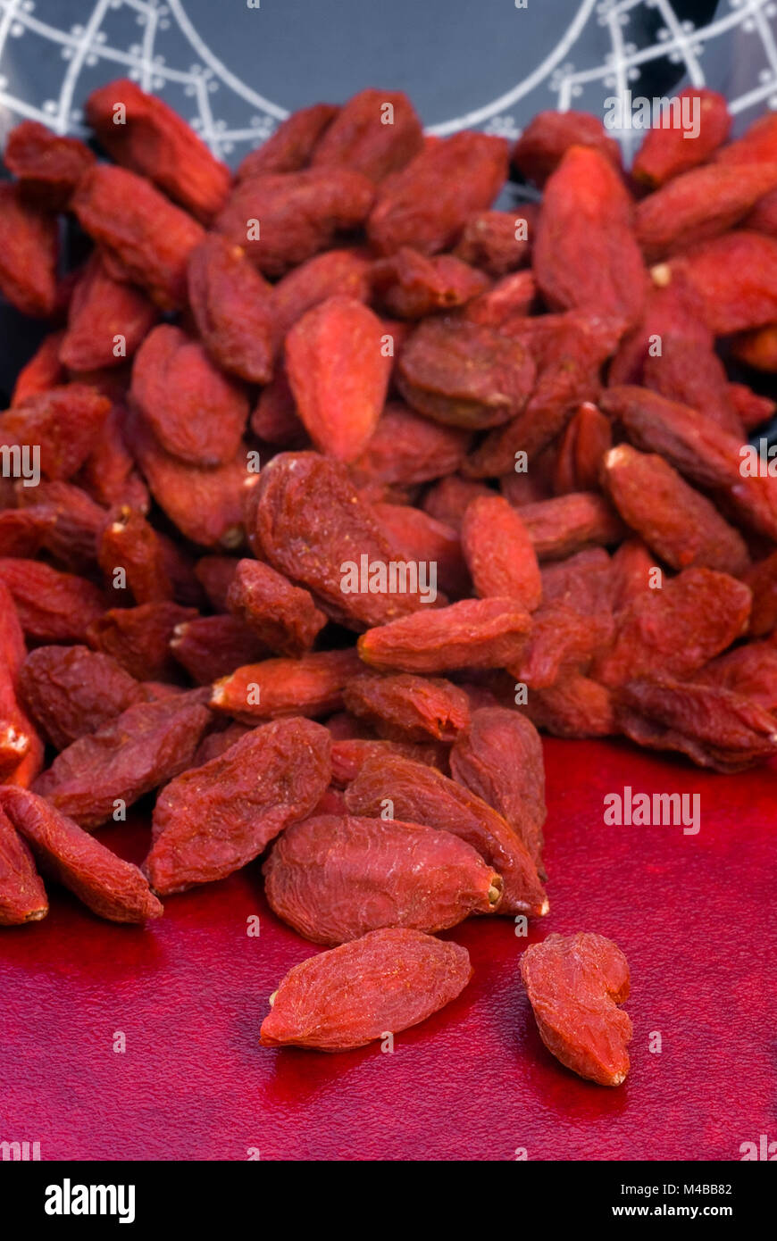 dry red goji berries (Lycium barbarum) on red background Stock Photo ...