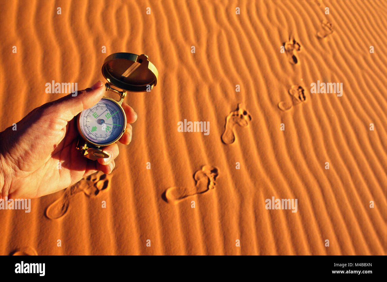 Algeria. Near Djanet. Sahara desert. Man using compass. Footsteps Stock ...