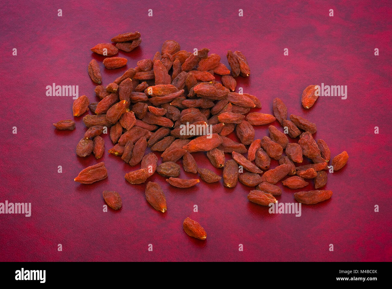 dry red goji berries (Lycium barbarum) on red background Stock Photo ...