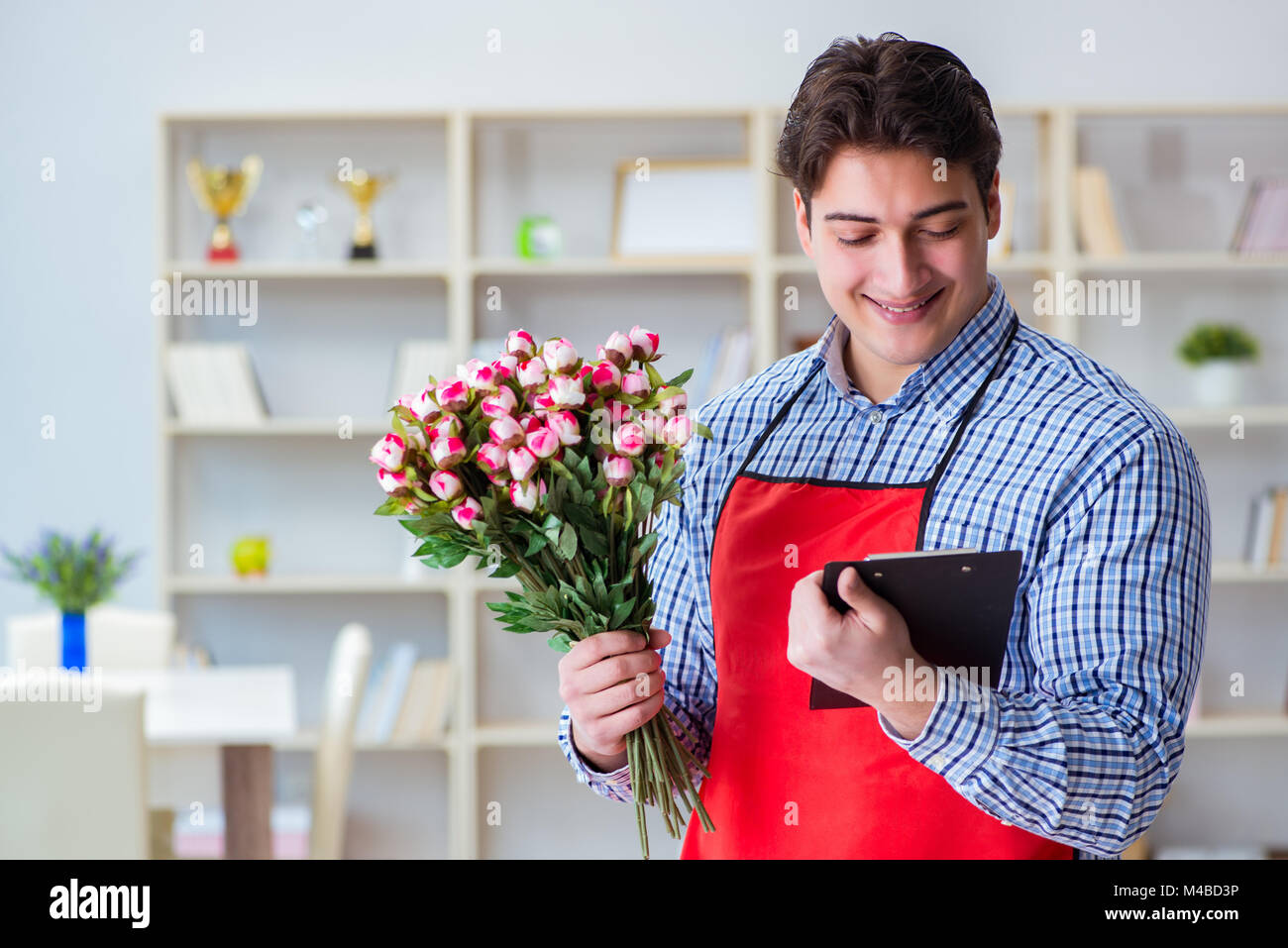 Flower shop assistant offering a bunch of flowers Stock Photo - Alamy