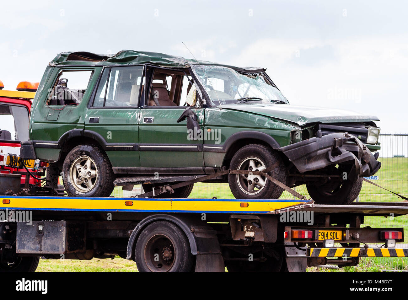 England. Badly damaged green land rover type car green after accident ...