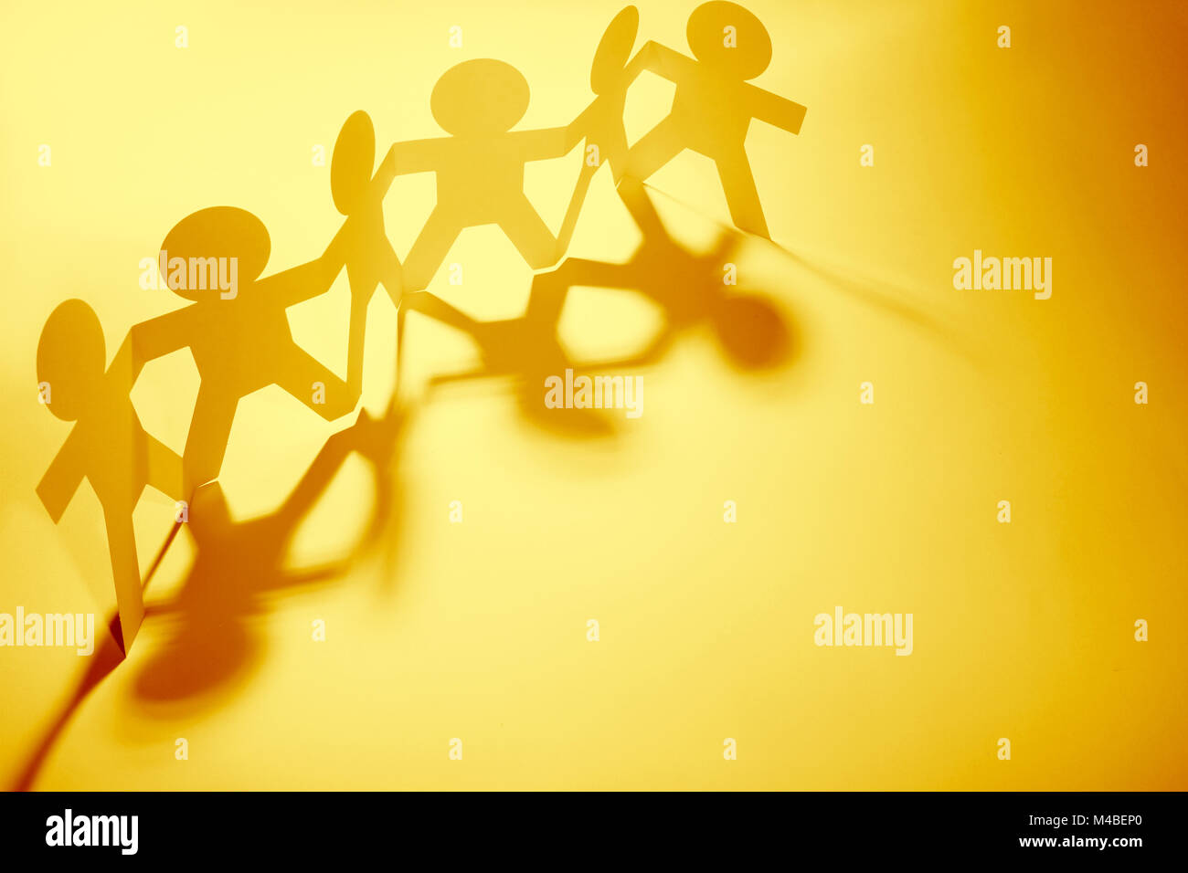 Team of paper chain people in a row holding hands Stock Photo - Alamy