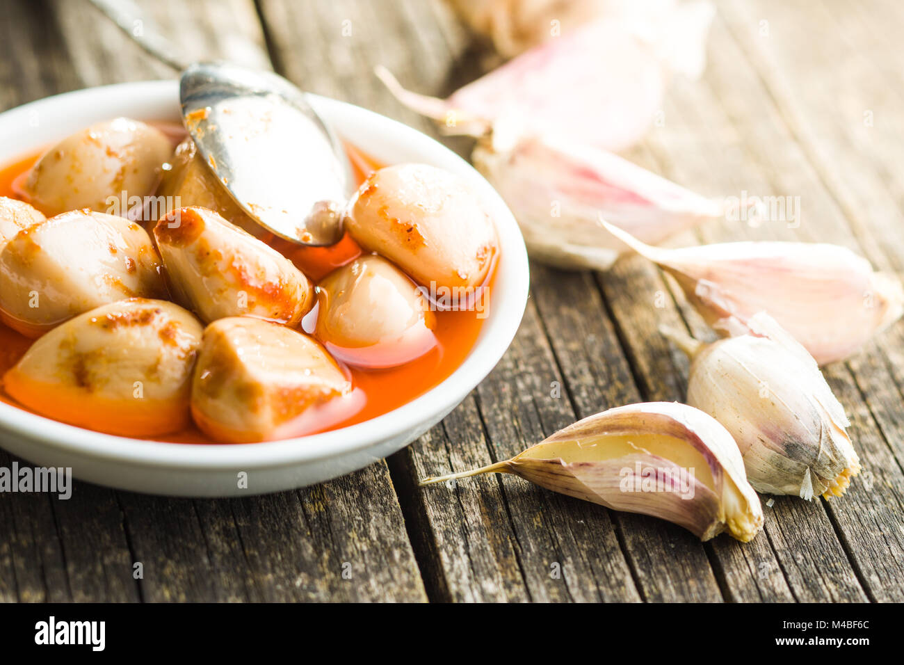 Tasty preserved garlic in bowl Stock Photo - Alamy