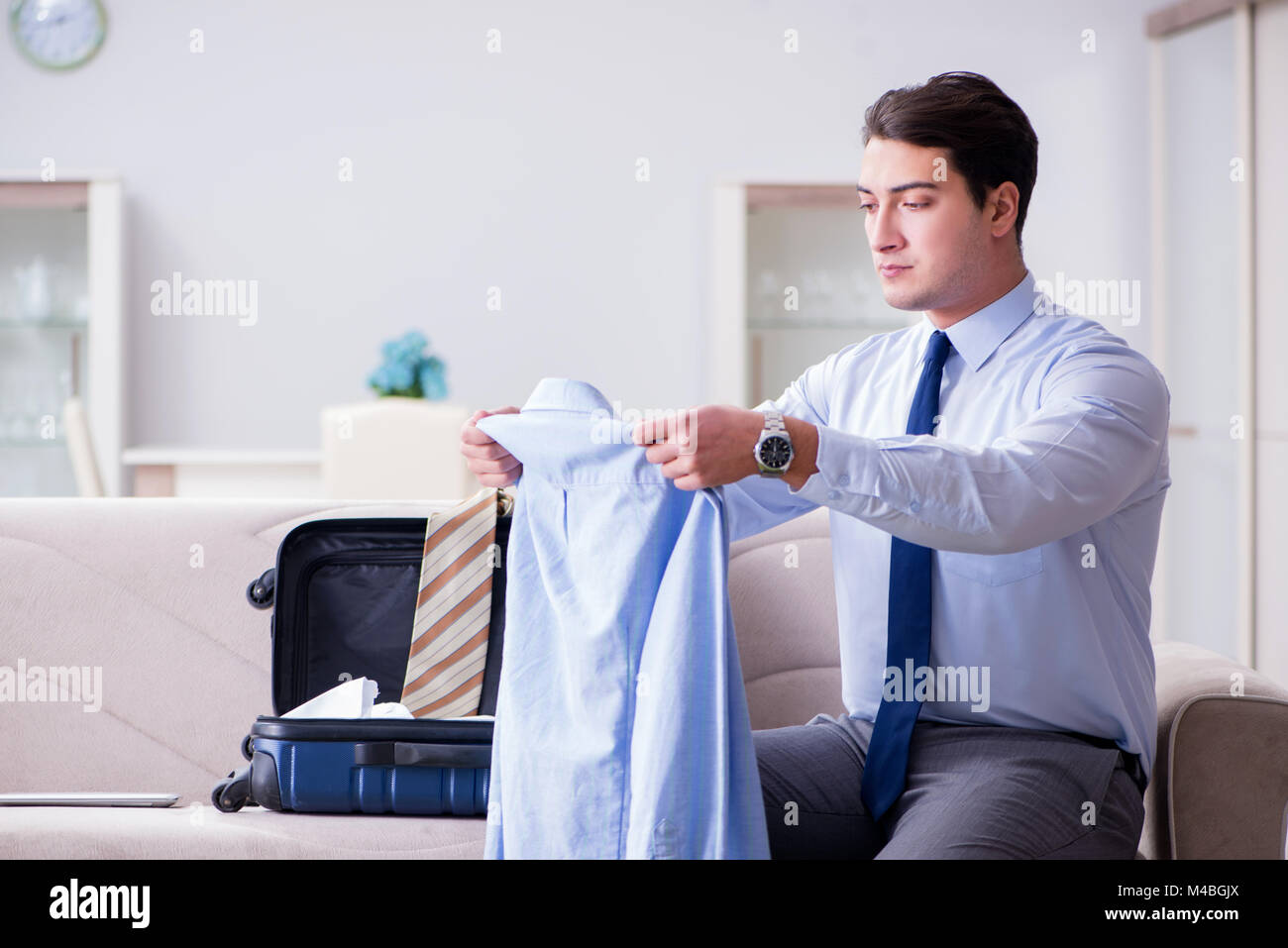 Businessman preparing packing for business trip Stock Photo - Alamy