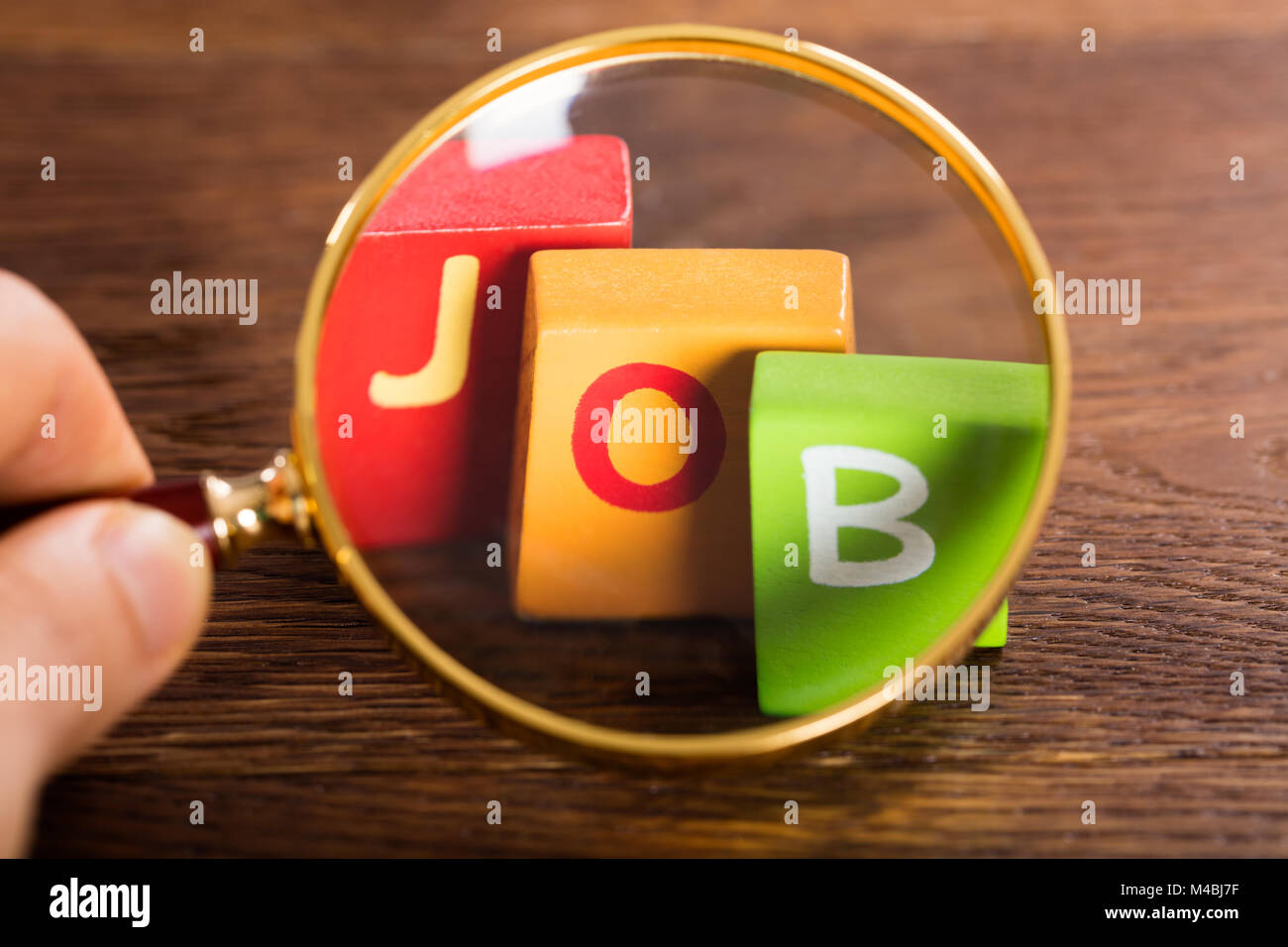 Person Holding Magnifying Glass Over The Word Job On Blocks Stock Photo ...
