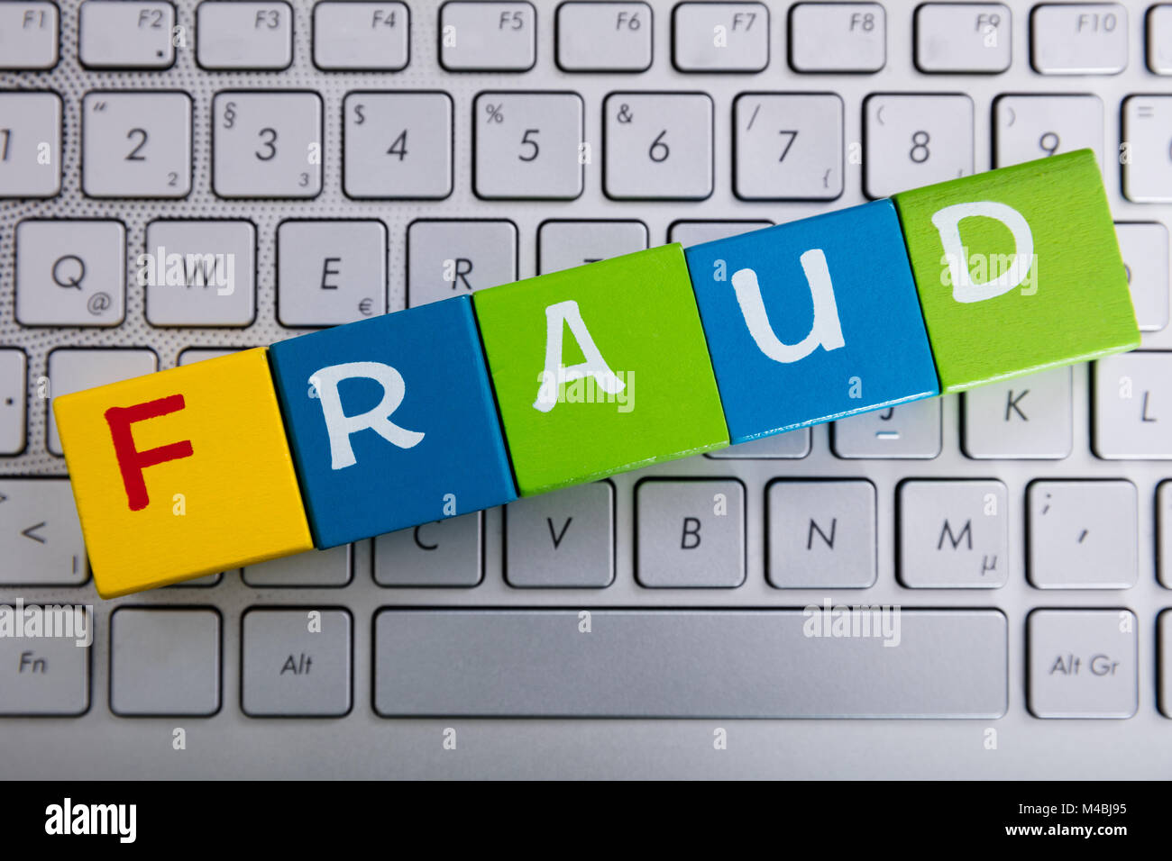 Fraud Word On Colorful Cubes Over Laptop Keyboard Stock Photo - Alamy