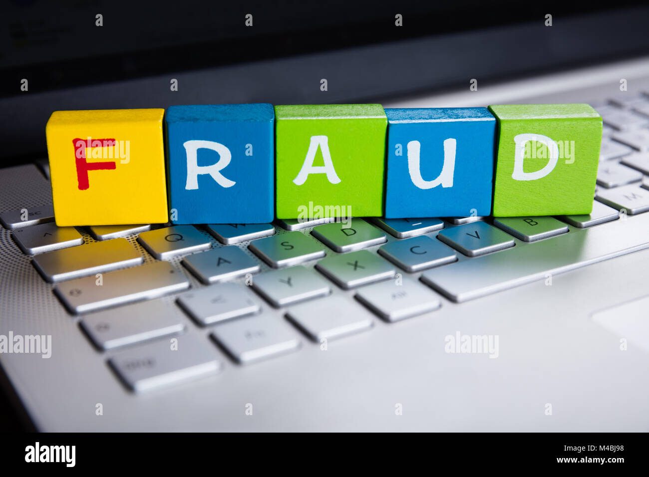 Fraud Word On Colorful Cubes Over Laptop Keyboard Stock Photo - Alamy