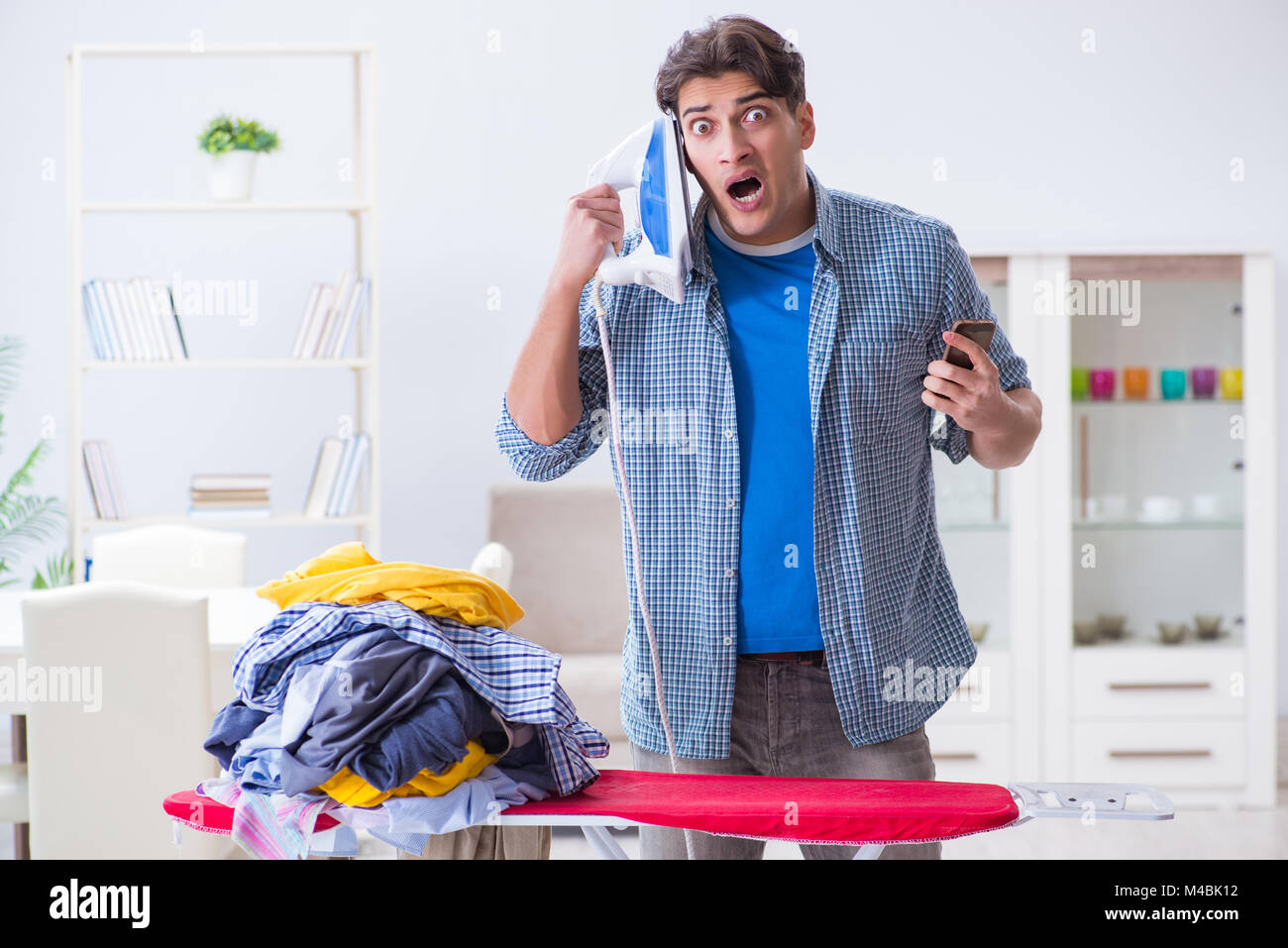 Young man husband doing clothing ironing at home Stock Photo - Alamy