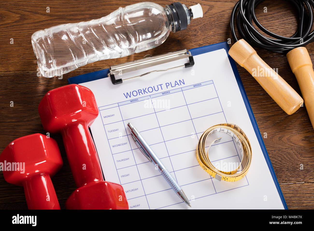 High Angle View Of Workout Plan Form With Fitness Equipments At Desk ...