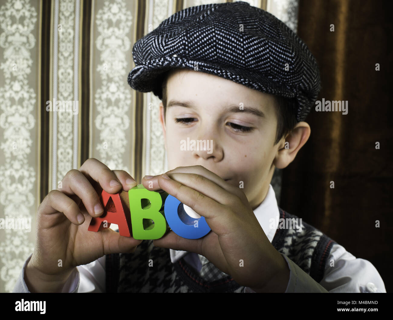 Child in vintage clothes hold letters a b c Stock Photo - Alamy