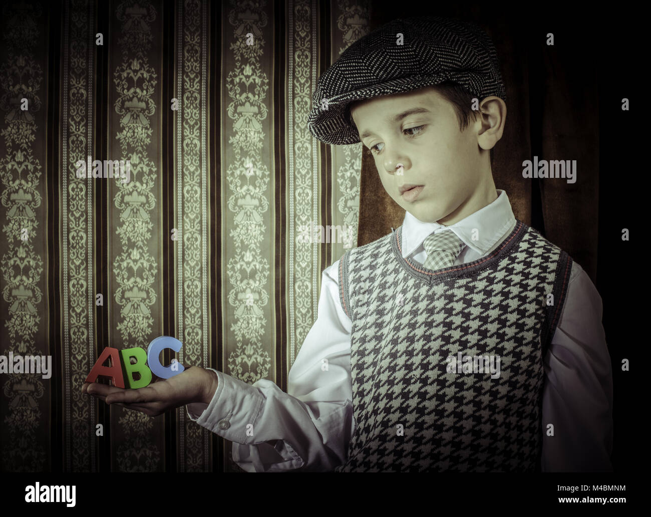 Child in vintage clothes hold letters a b c Stock Photo - Alamy