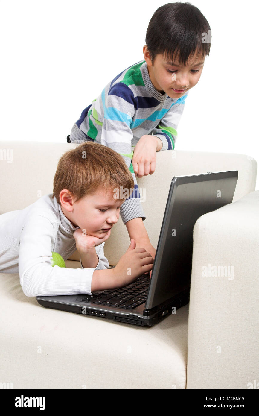 Two boys with laptop on the sofa Stock Photo - Alamy