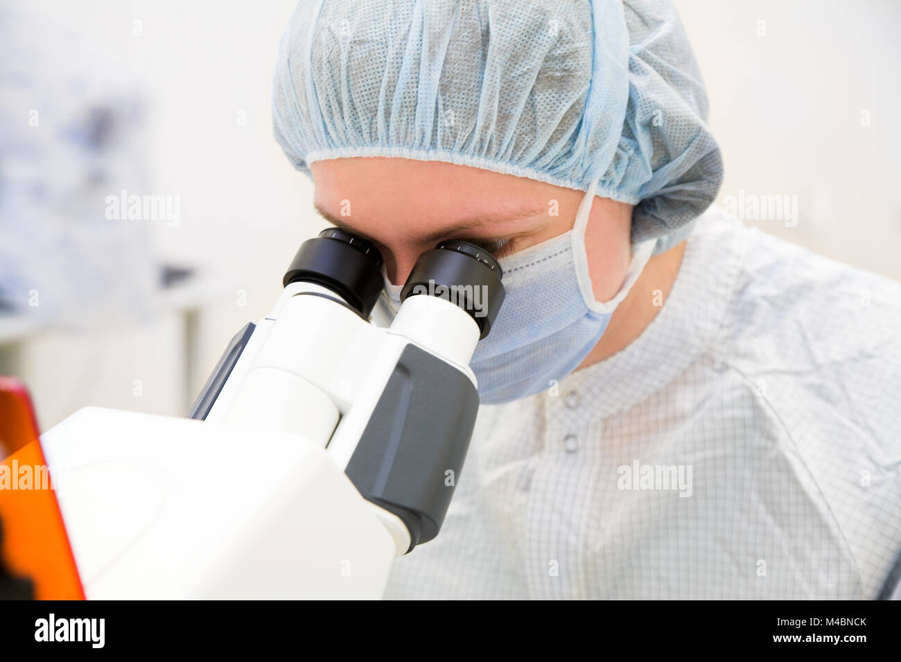 Woman looking in microscope Stock Photo - Alamy
