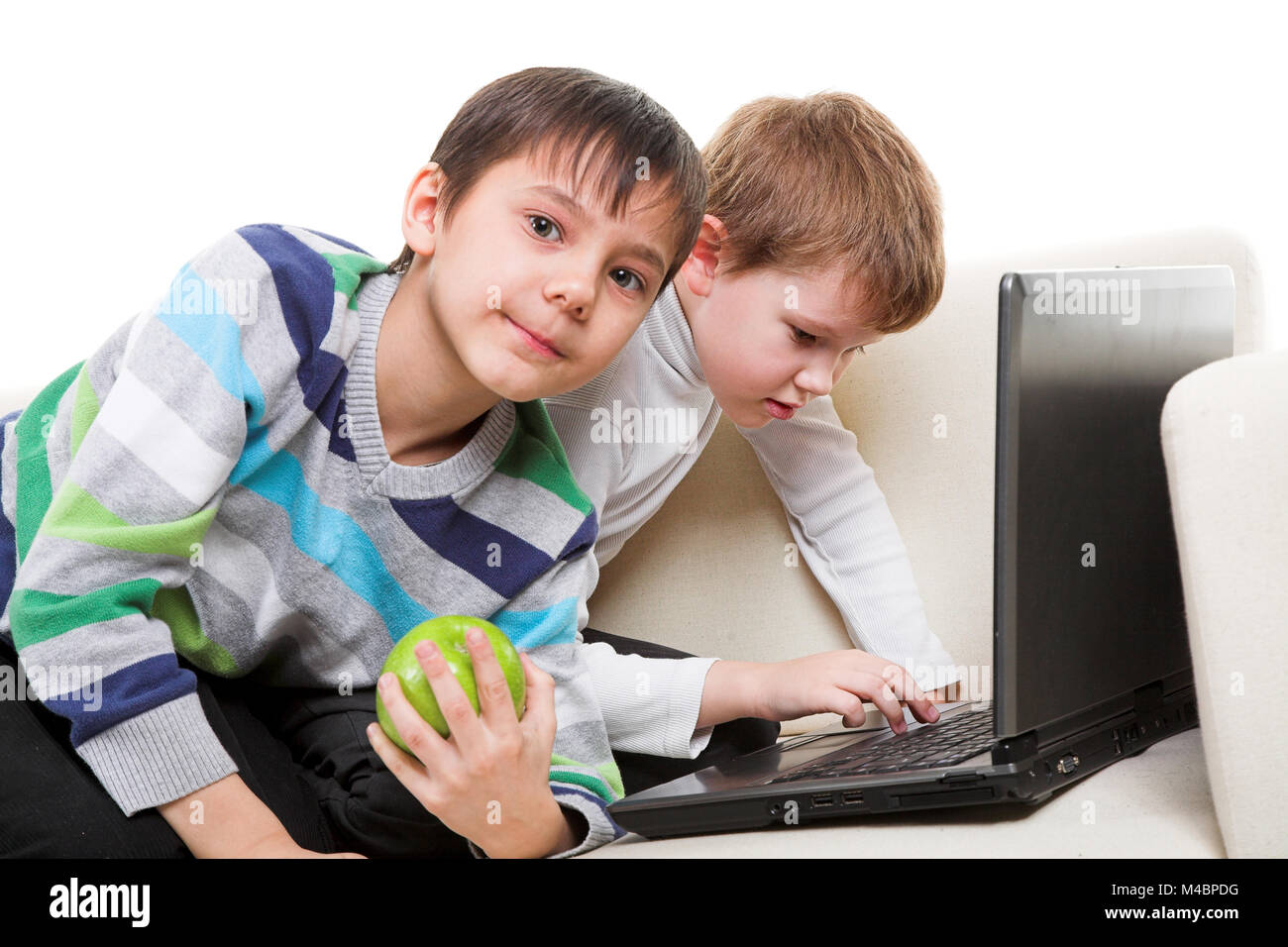 Two boys with laptop on the sofa Stock Photo - Alamy