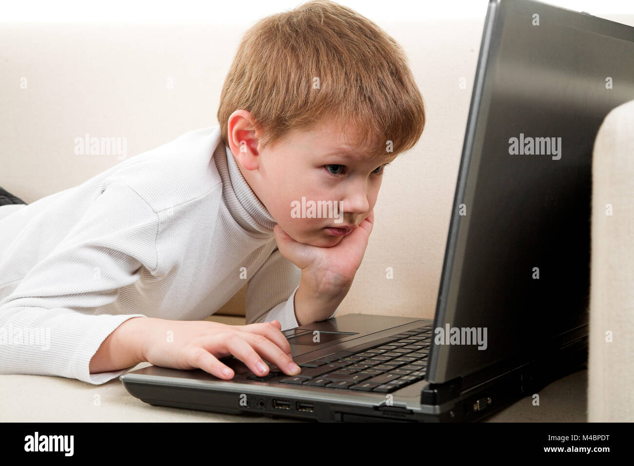 Two boys with laptop on the sofa Stock Photo - Alamy