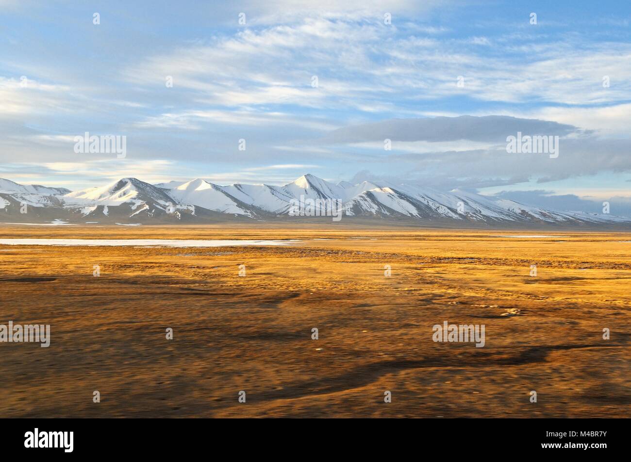 Snow covered mountains of Tibetan high plateau in sunlight Stock Photo ...