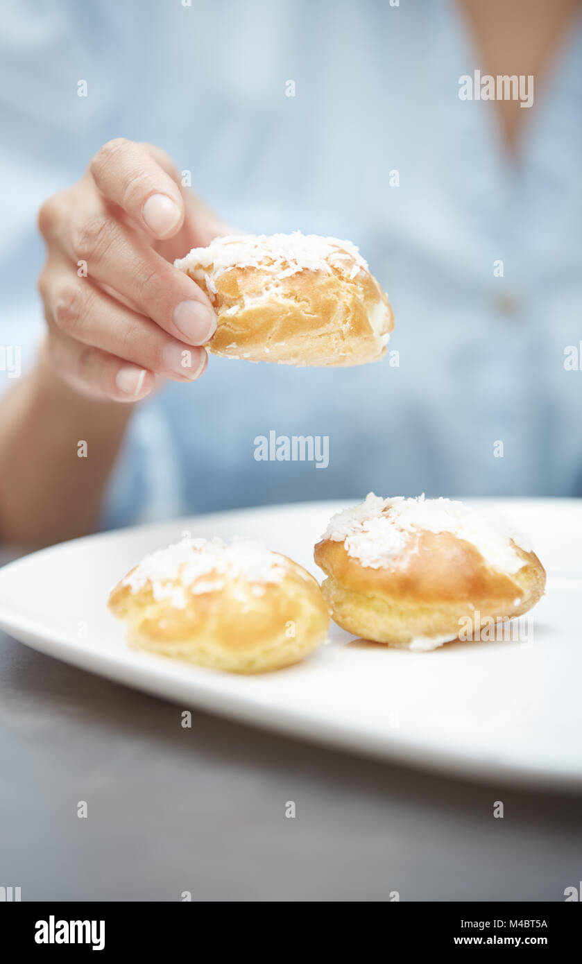 Woman eating eclairs Stock Photo - Alamy