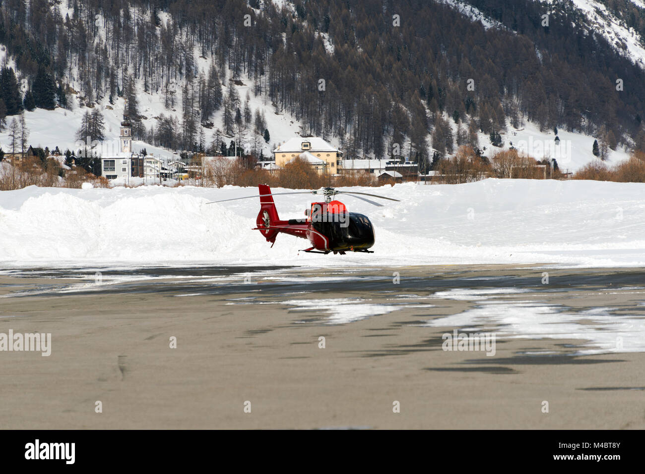 A red airport helicopter in the snow in the alps switzerland Stock ...