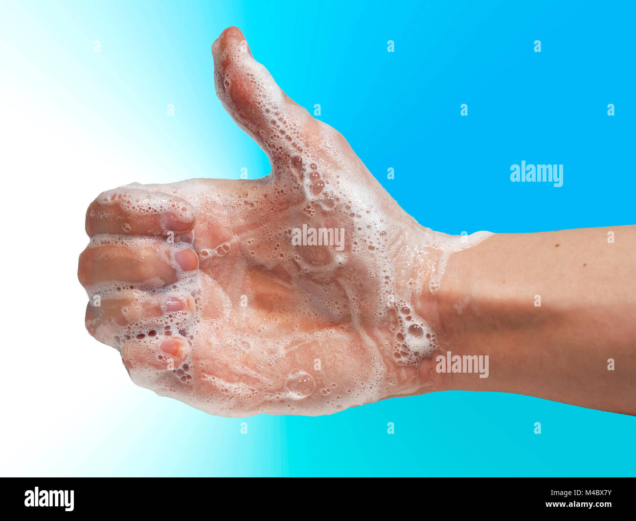 Soapy womens hand making thumbs up,isolated on blue white background ...
