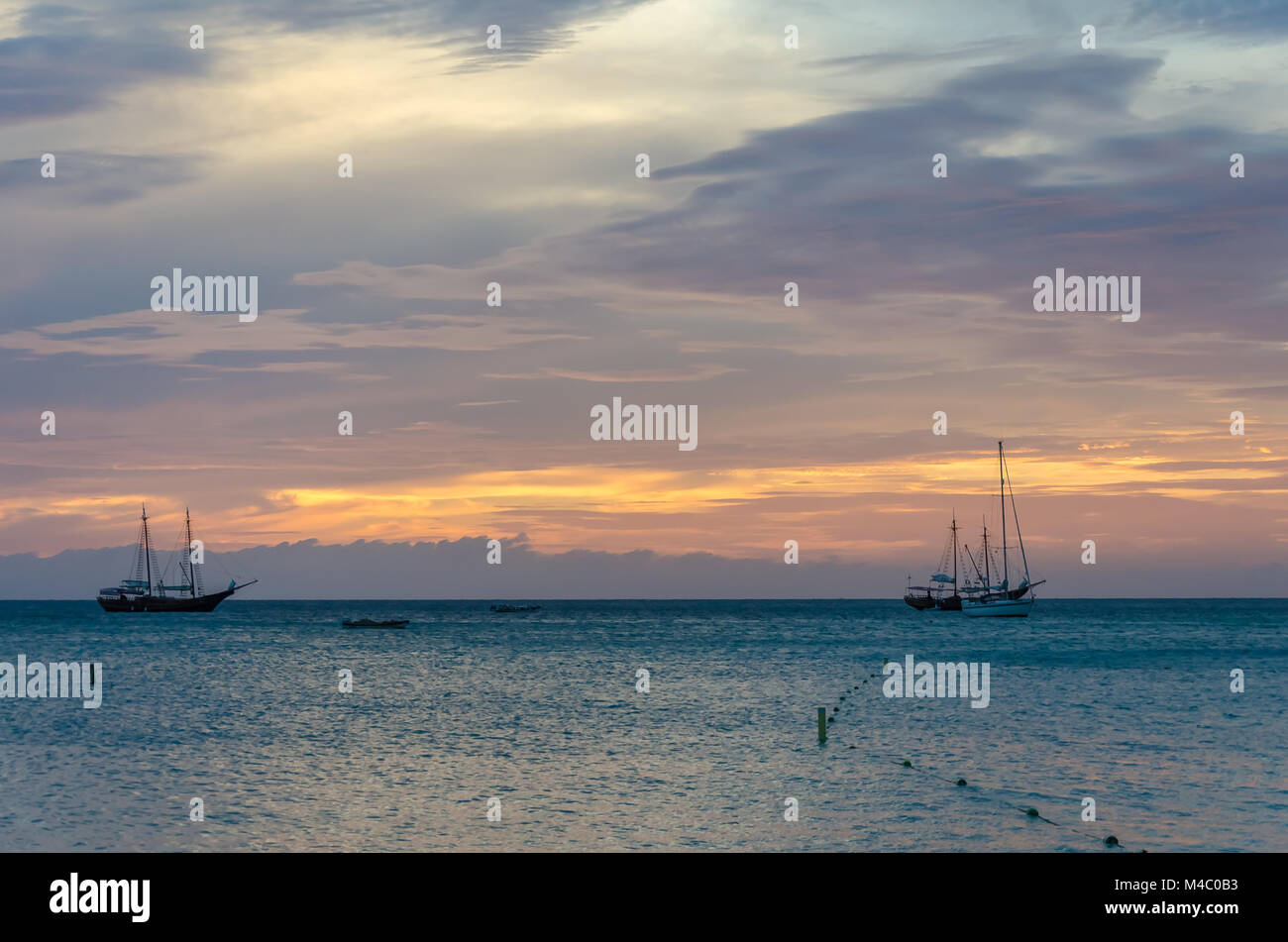 the Golden hour with sail boats on sea anchored Stock Photo - Alamy