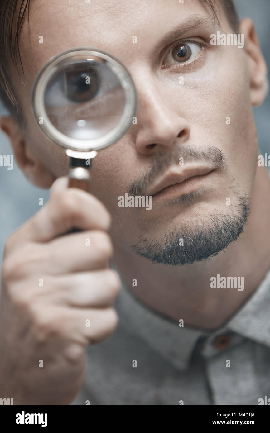 Man with magnifying glass Stock Photo - Alamy