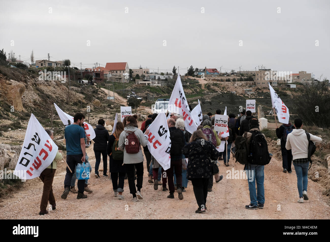 Israeli left-wing activists stand with flags of the Peace Now movement ...
