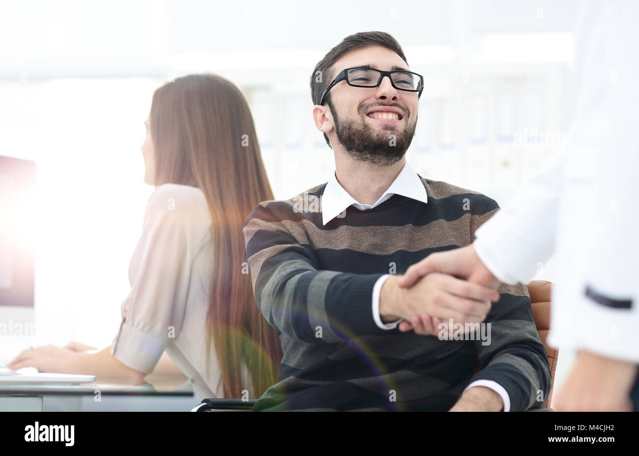 handshake between colleagues in the workplace Stock Photo - Alamy