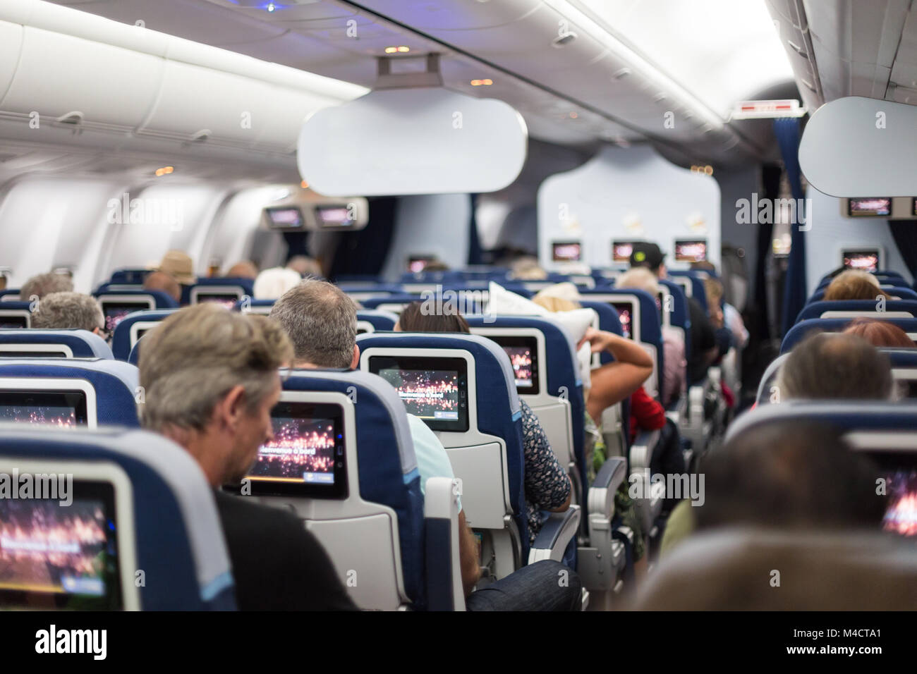 Interior of large commercial airplane with passengers on seats waiting ...