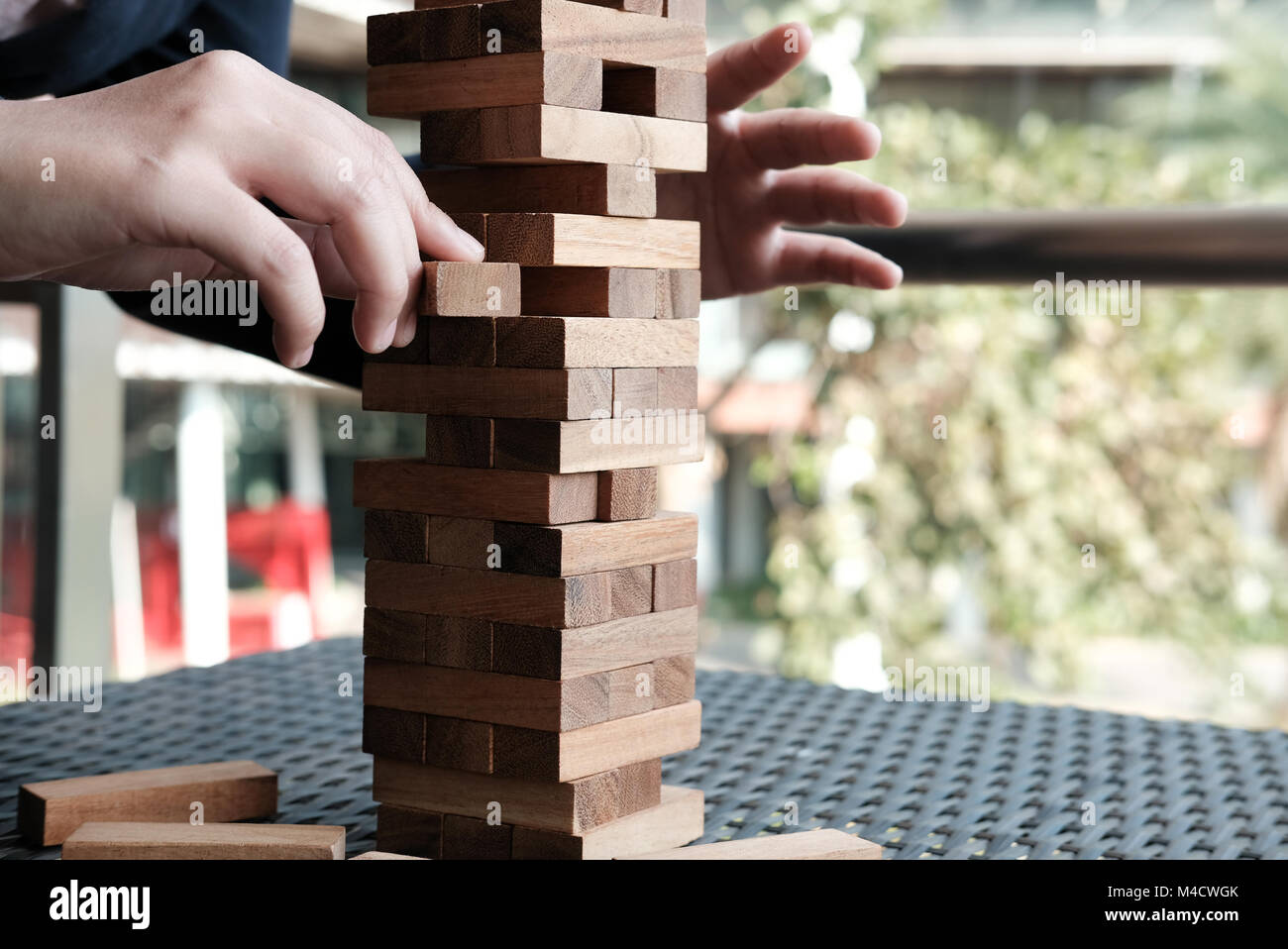 businesswoman hand pull out wood block from tower. growth, risk ...