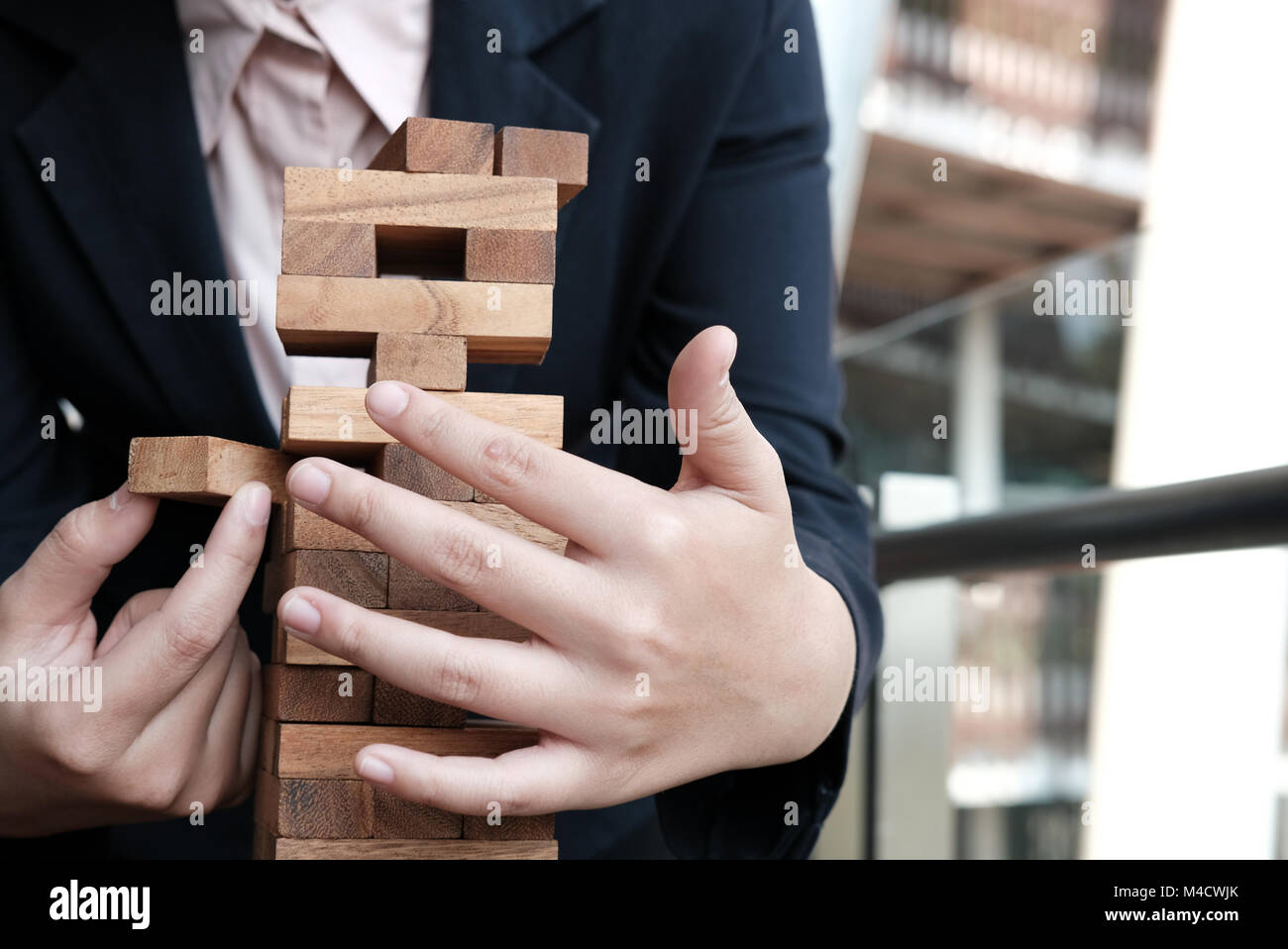 businesswoman hand pull out wood block from tower. growth, risk ...