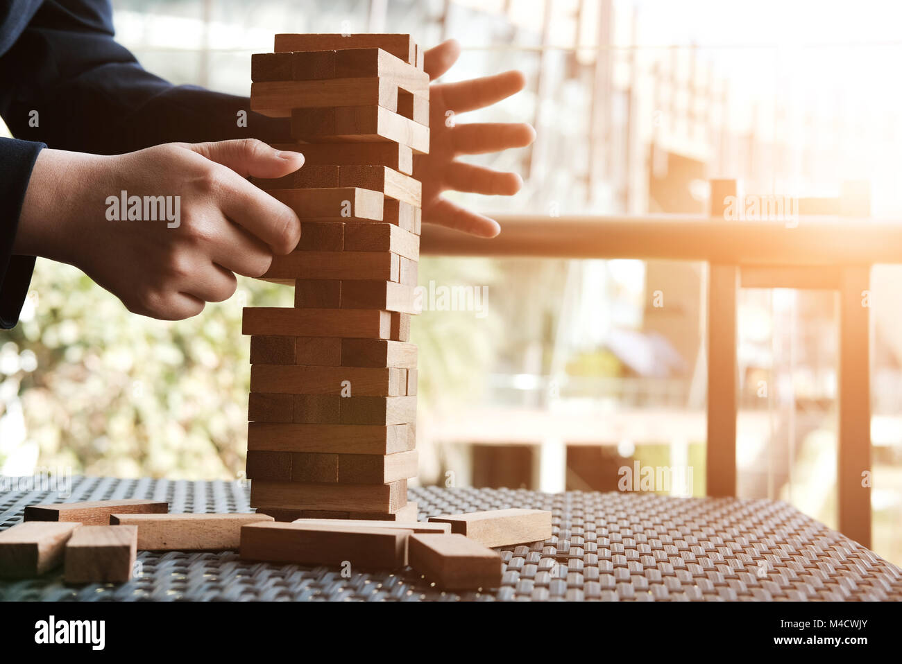 businesswoman hand pull out wood block from tower. growth, risk ...