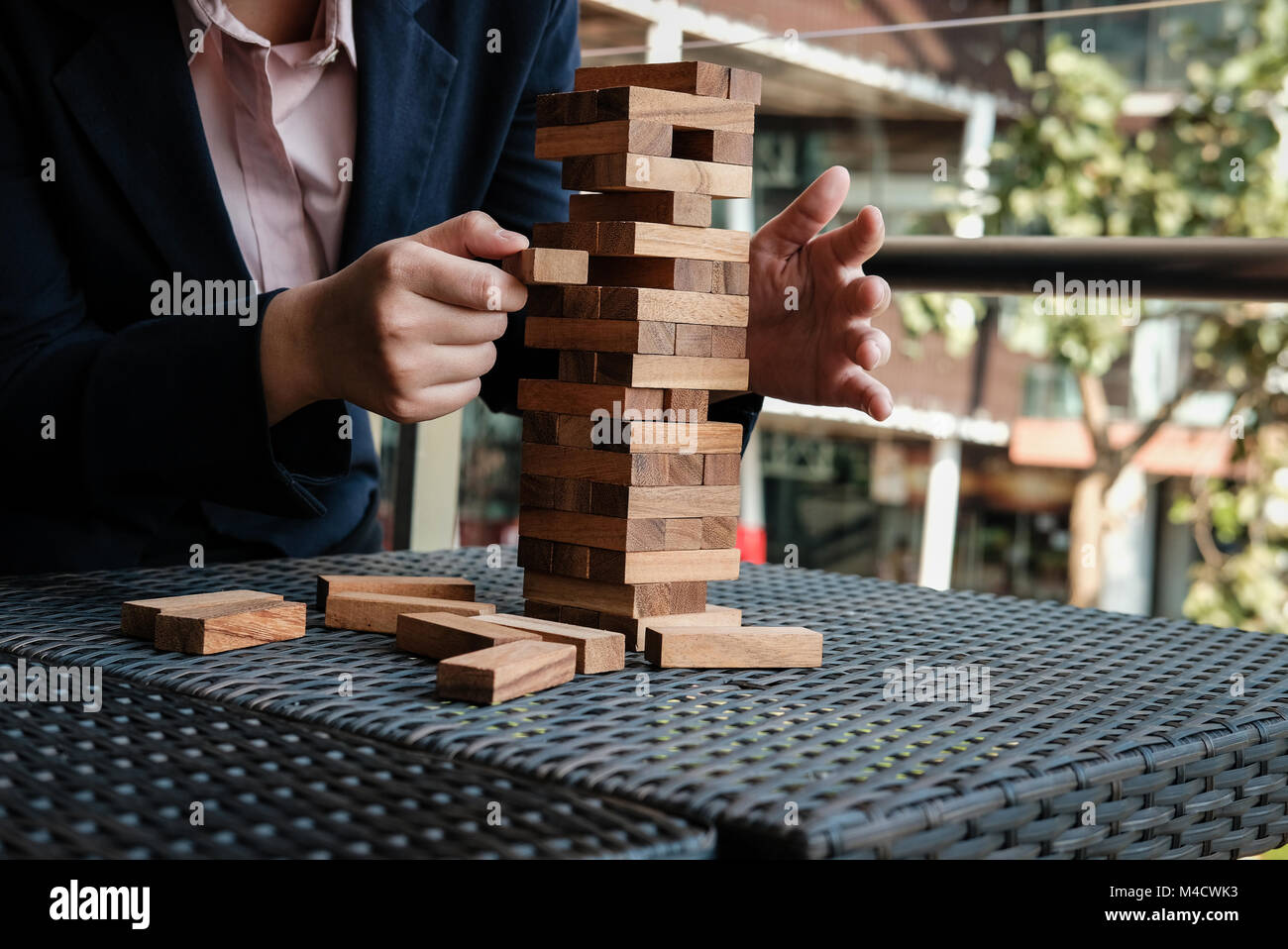 businesswoman hand pull out wood block from tower. growth, risk ...