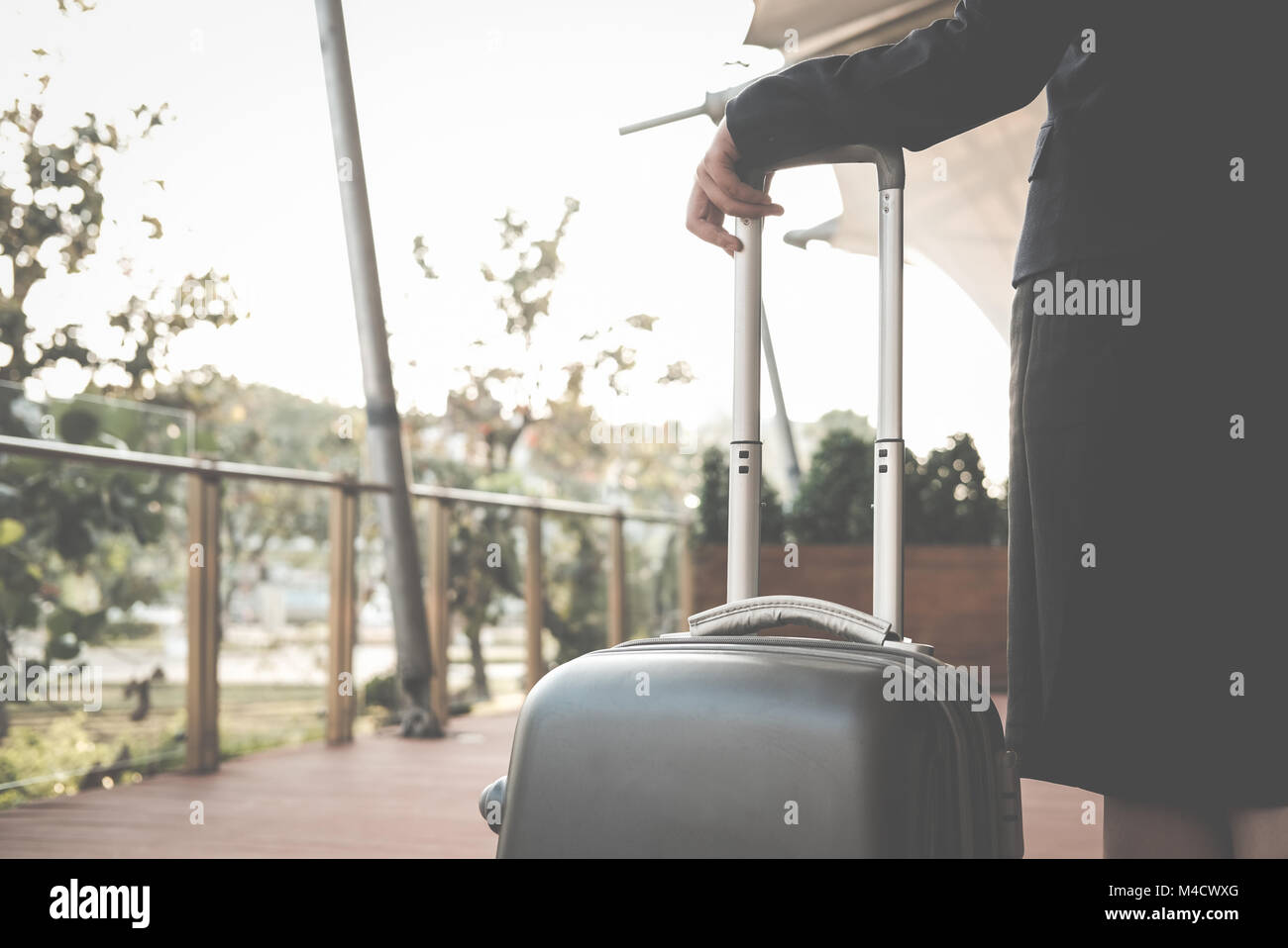 businesswoman pulling luggage outdoors. woman carrying baggage for ...