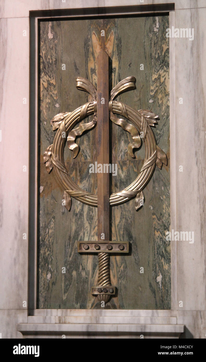 Sword nailed in a frame in wall against a twig wreath in the Basilica ...