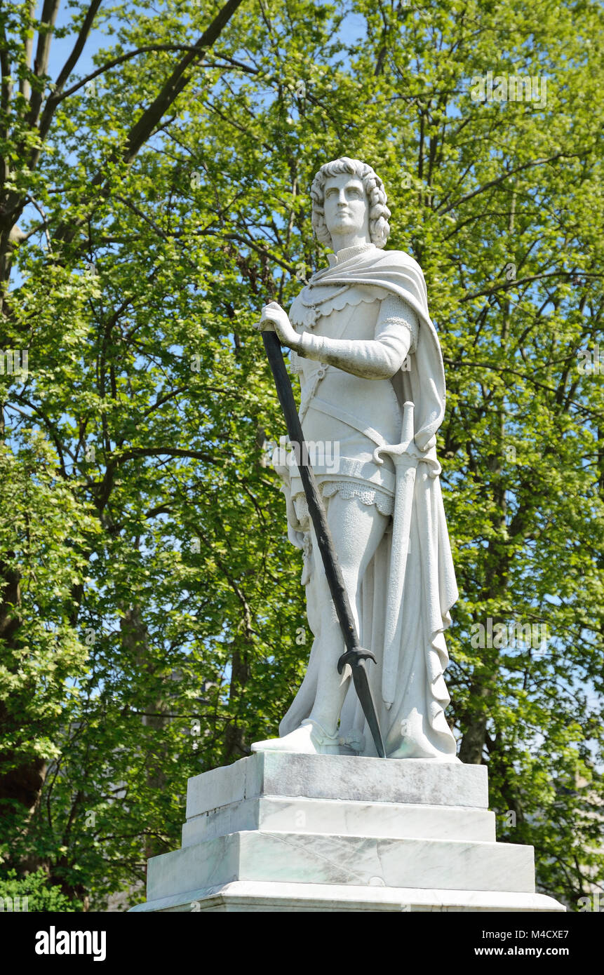 The sculpture of Gaston Febus among the green trees in the French city ...