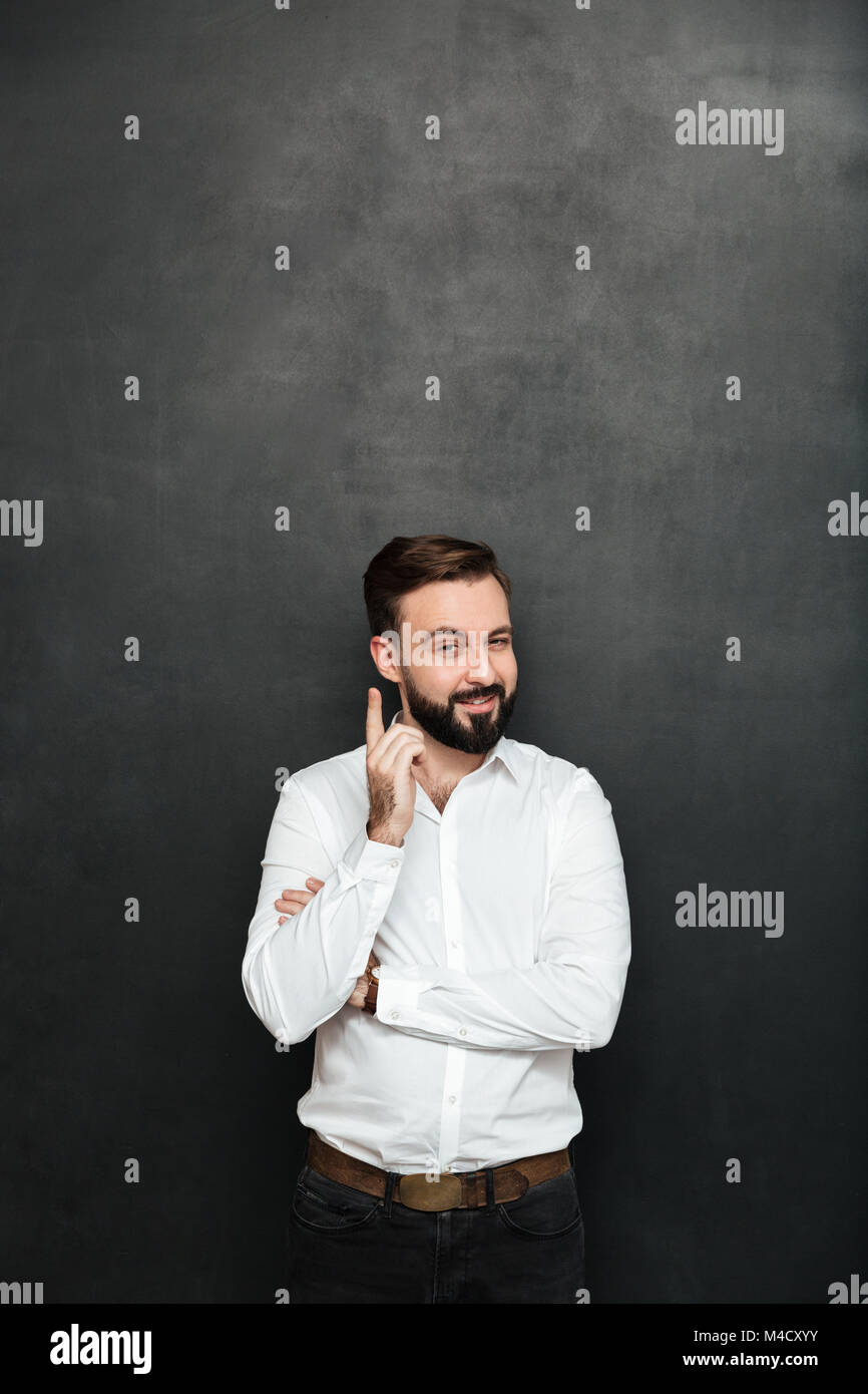 Brunette businessman posing on camera with tricky happy look pointing ...