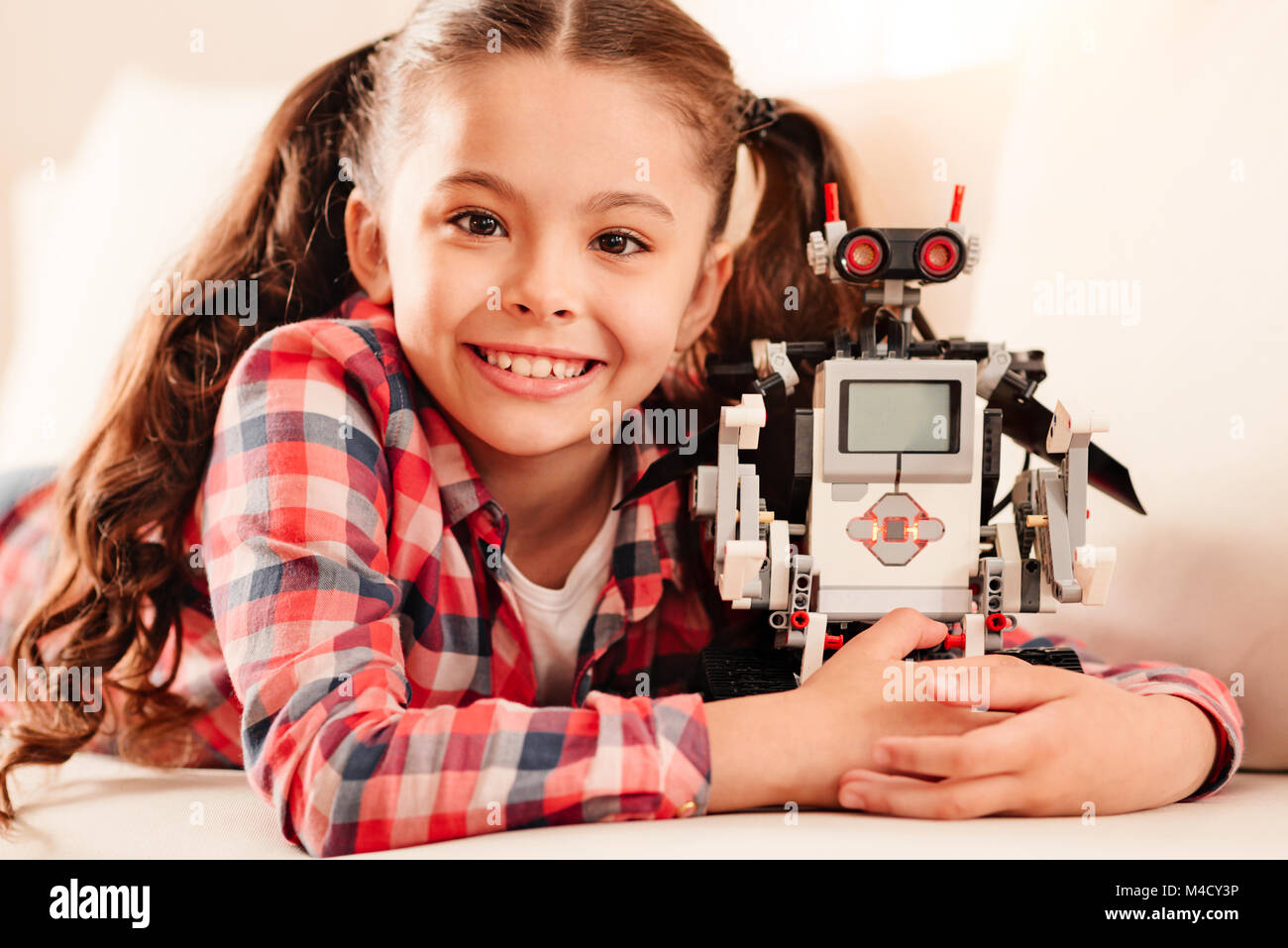 Beaming little girl embracing her new robot toy Stock Photo - Alamy