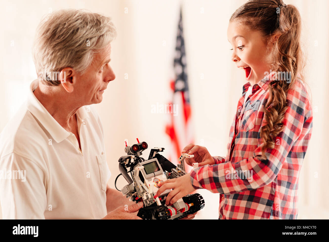 Emotional little girl getting excited over robot toy Stock Photo - Alamy