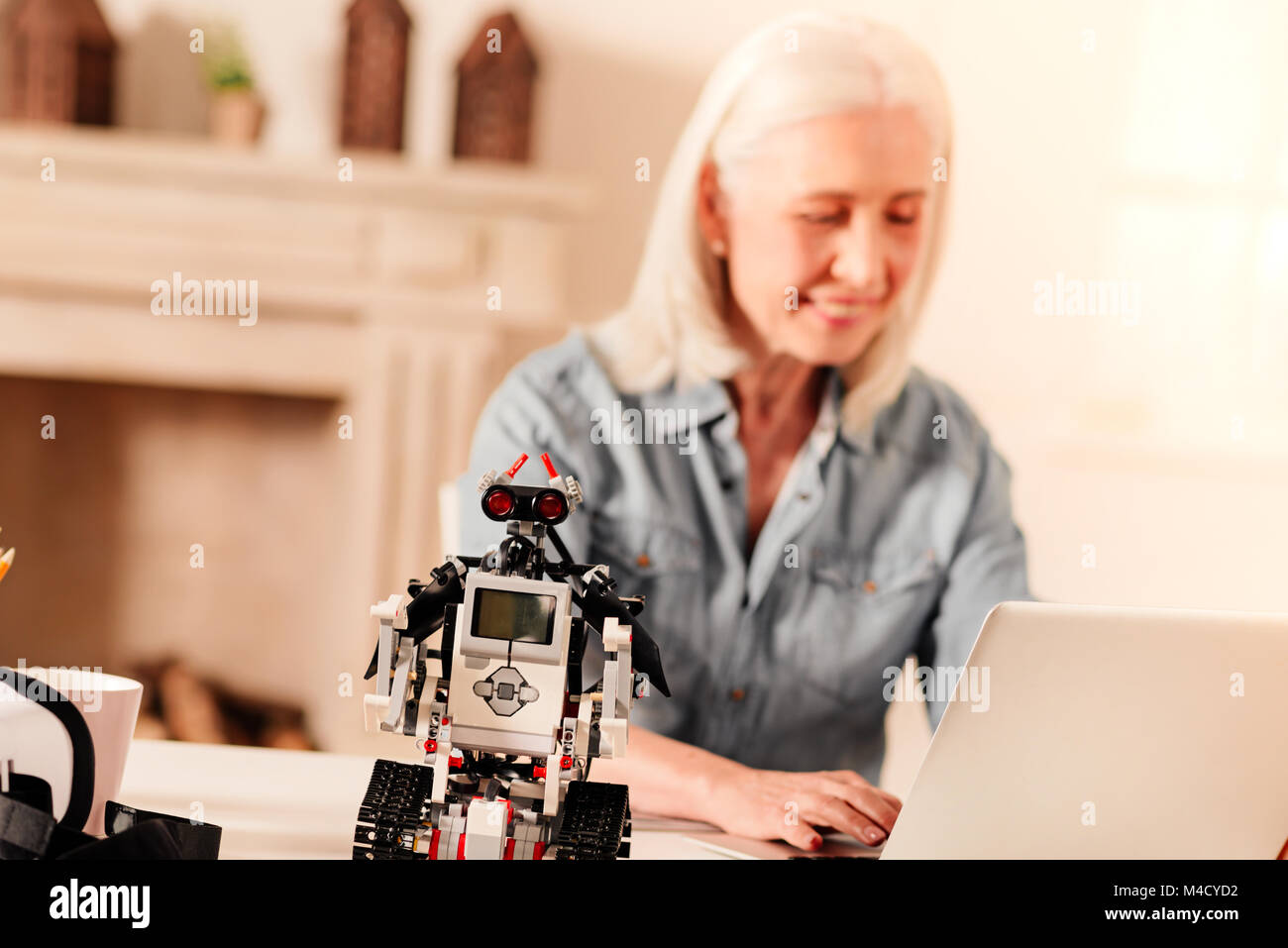 Impressive robot standing on table of elderly lady Stock Photo - Alamy