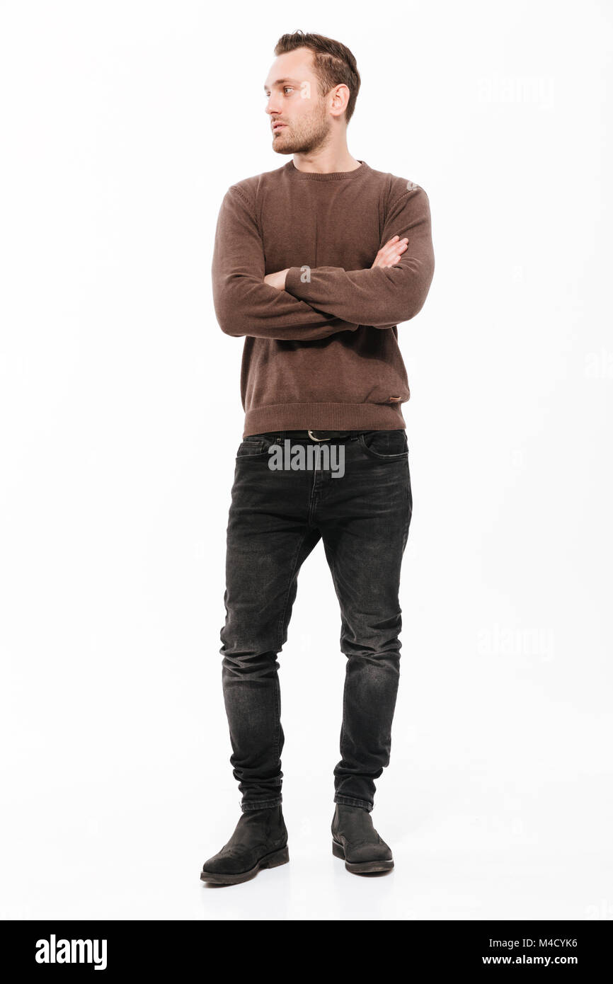 Image of serious young man standing isolated over white background ...