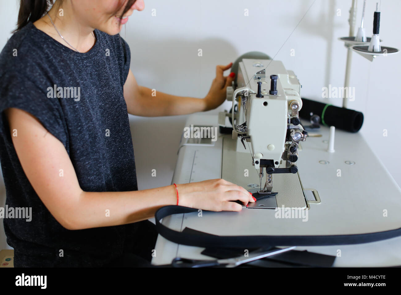Seamstress sewing belt using sewing machine Stock Photo - Alamy