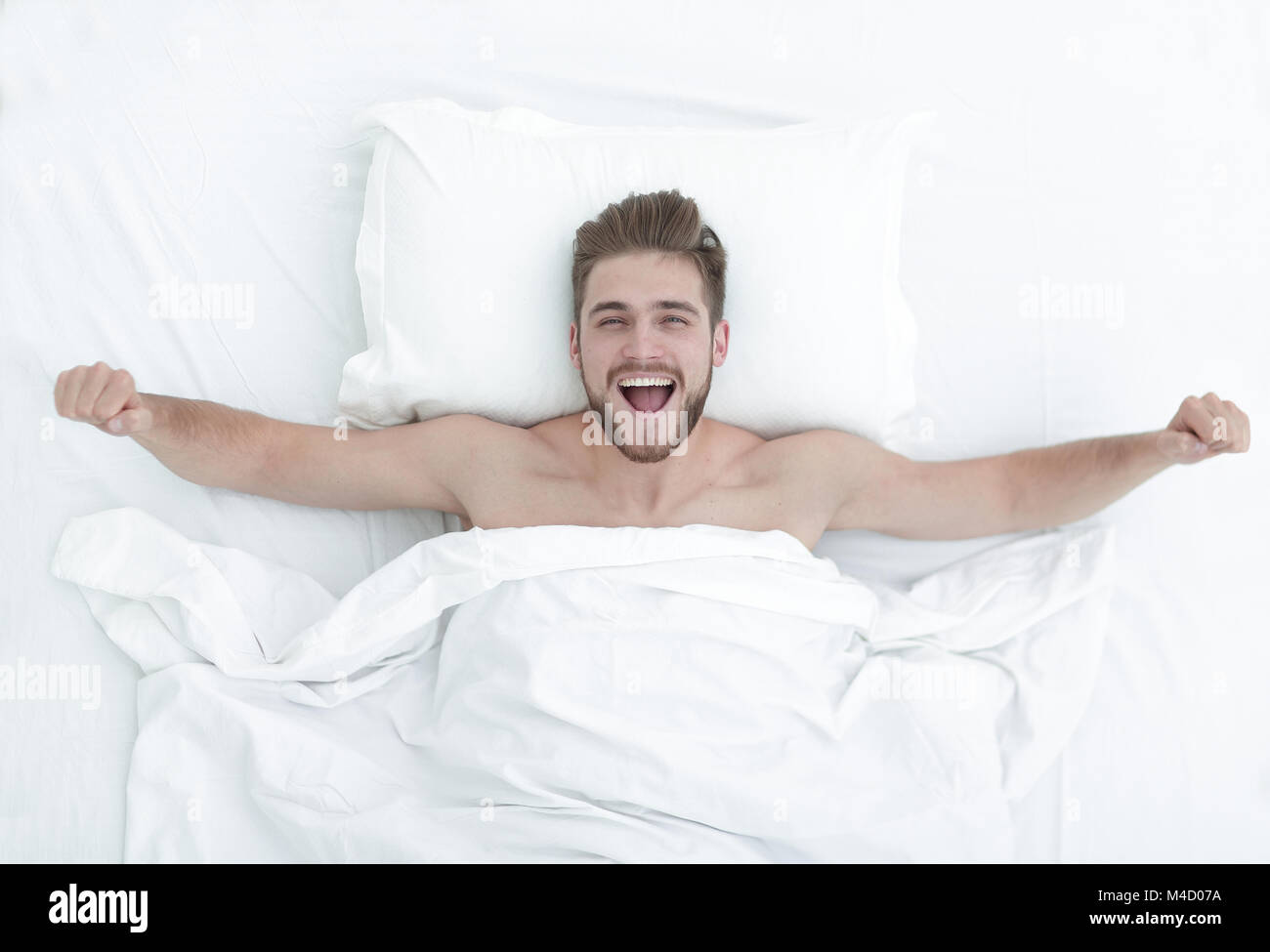 top view. happy man waking up in a comfortable bed Stock Photo - Alamy
