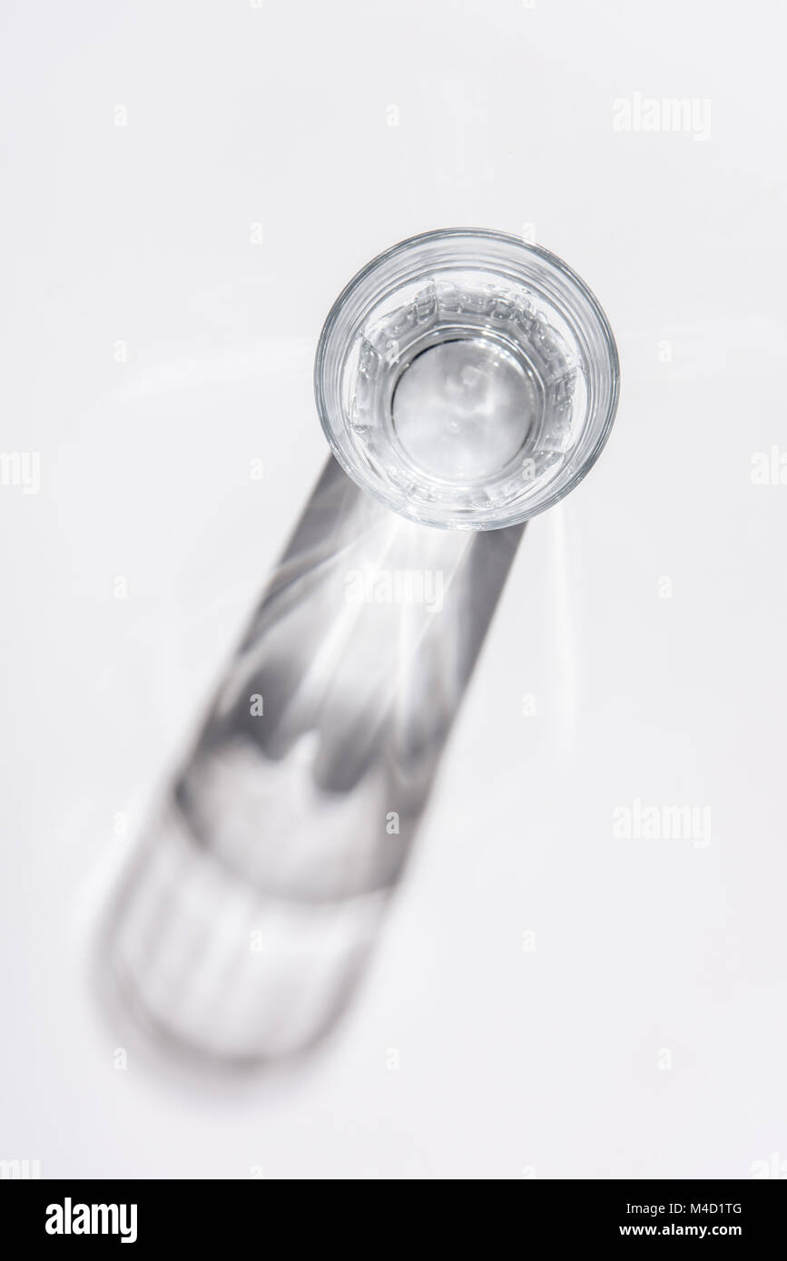 top view of glass with water on white table Stock Photo - Alamy