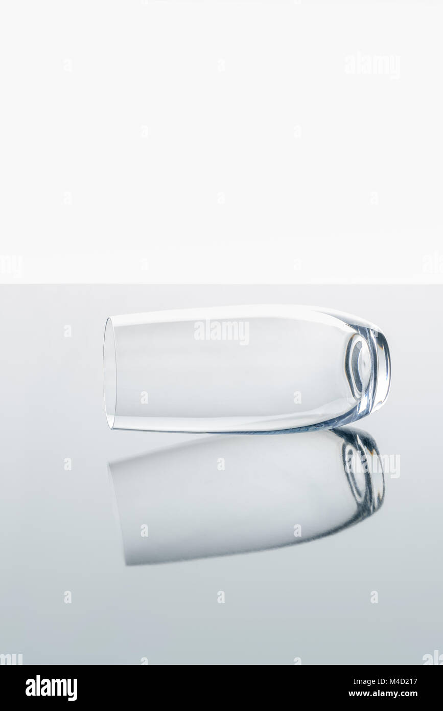 one glass on white reflecting surface Stock Photo - Alamy