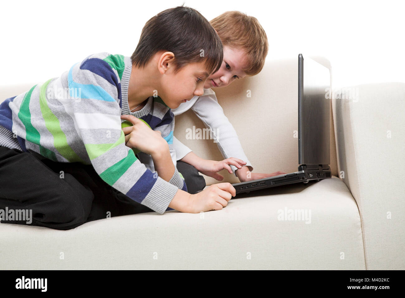 Two boys with laptop on the sofa Stock Photo - Alamy