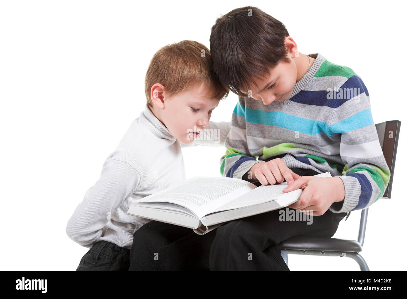 Two boys reading big book Stock Photo - Alamy