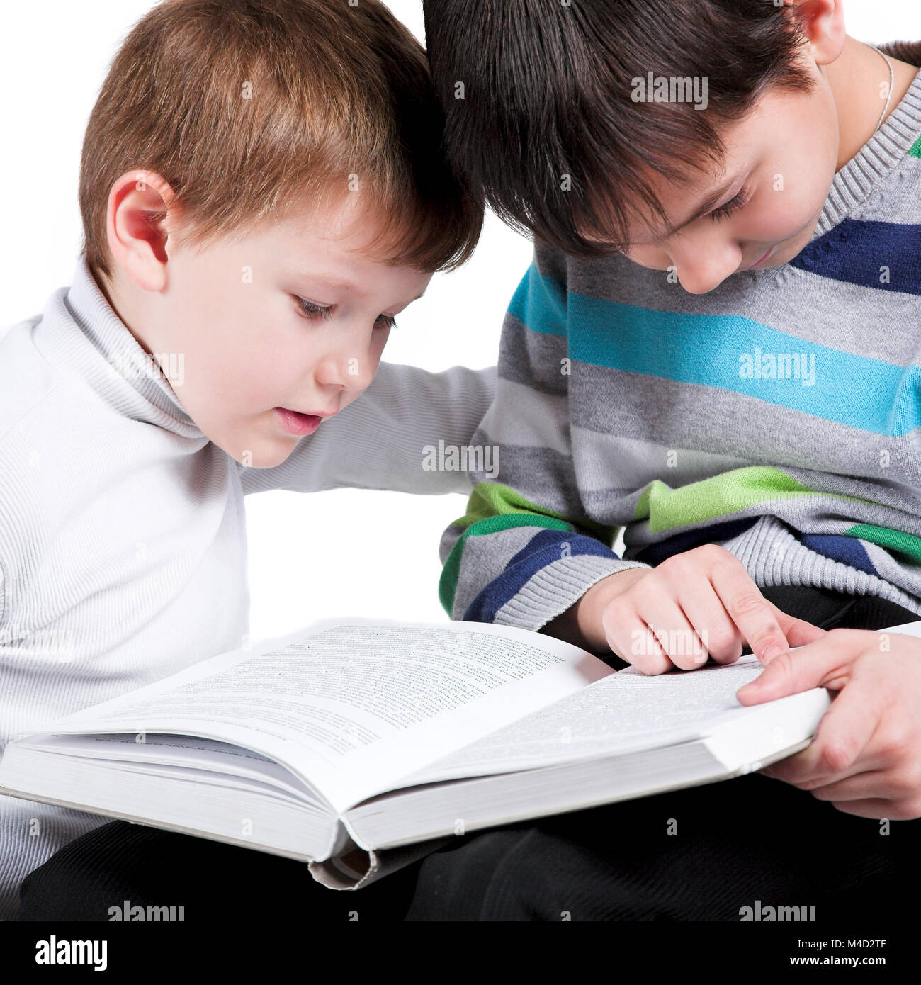 Two boys reading big book Stock Photo - Alamy