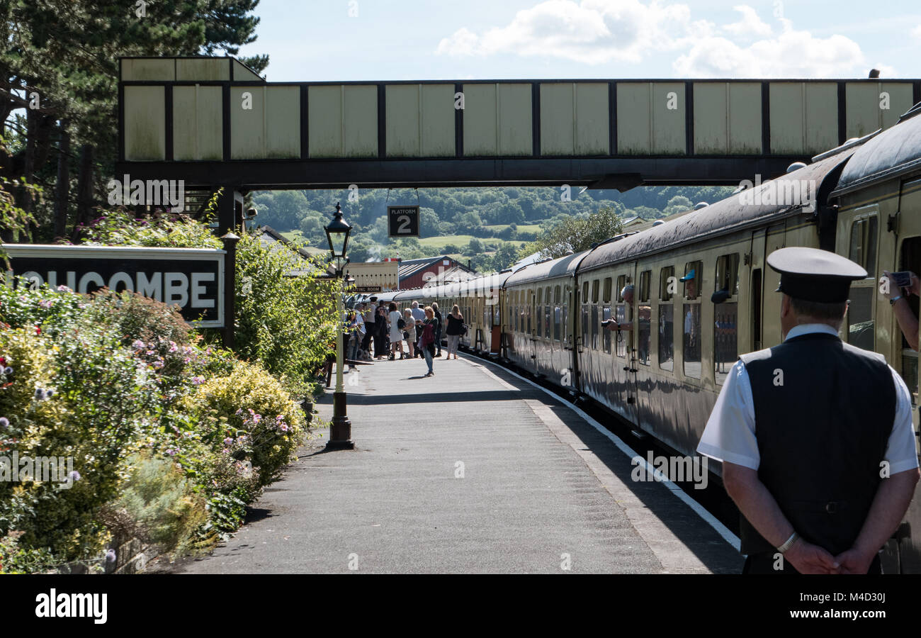 Train guard waits as travellers alight and join a heritage steam train ...